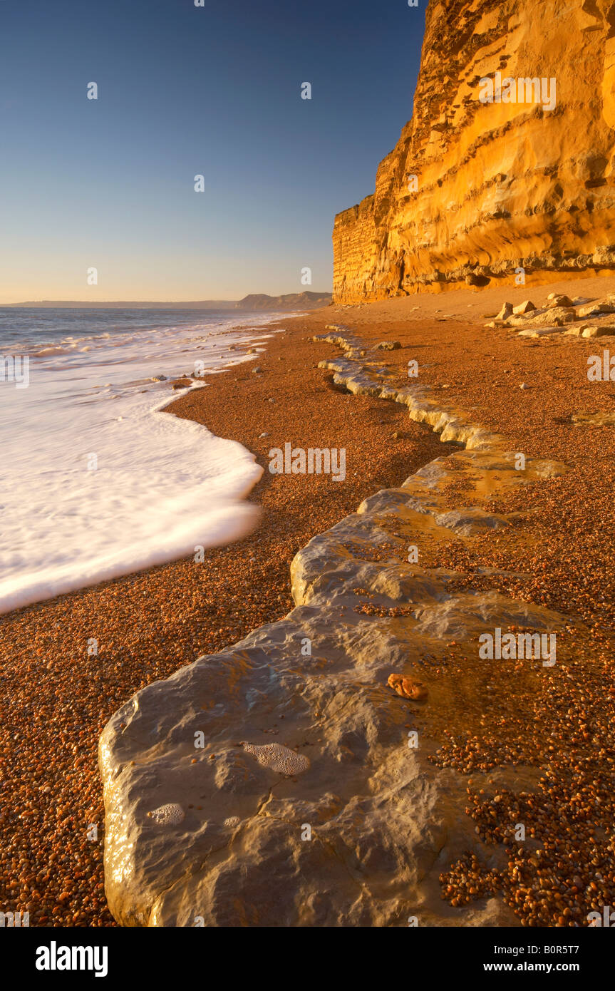Waves rushing in over the beach and jurassic rock shelf at Burton ...
