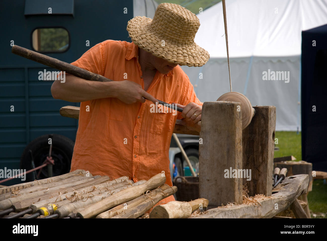 A crafsman demonstrates the use of a traditonal foot powered wood lathe ...