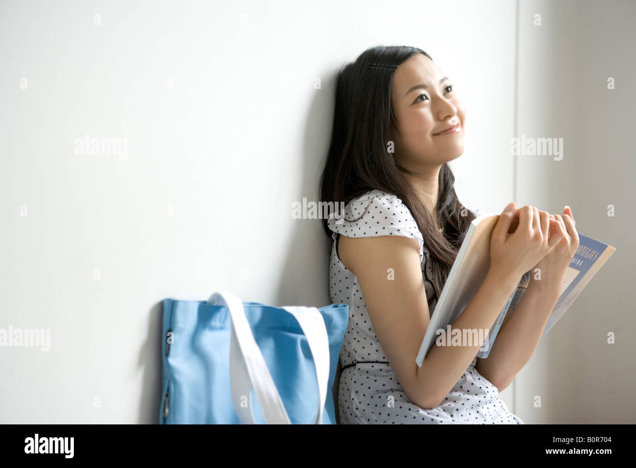 Young woman sitting with book Stock Photo - Alamy