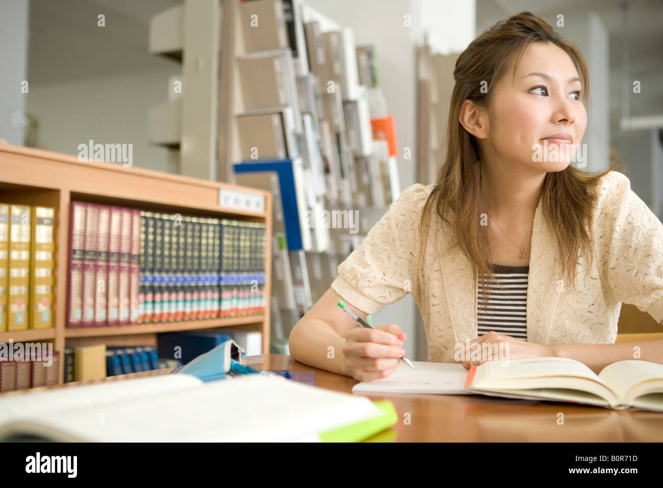 Young woman studying in library Stock Photo - Alamy
