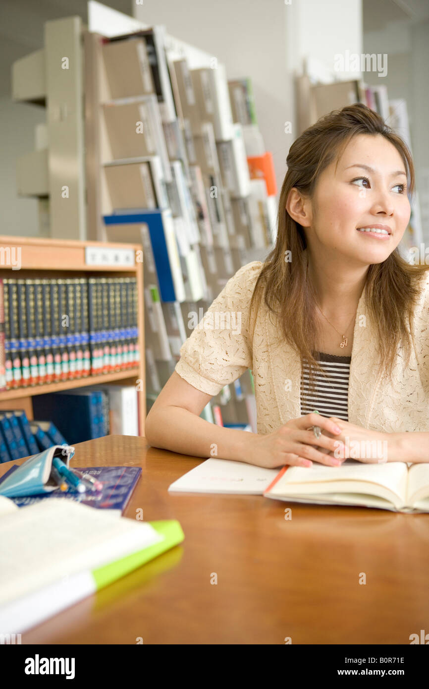 Young woman studying in library Stock Photo - Alamy