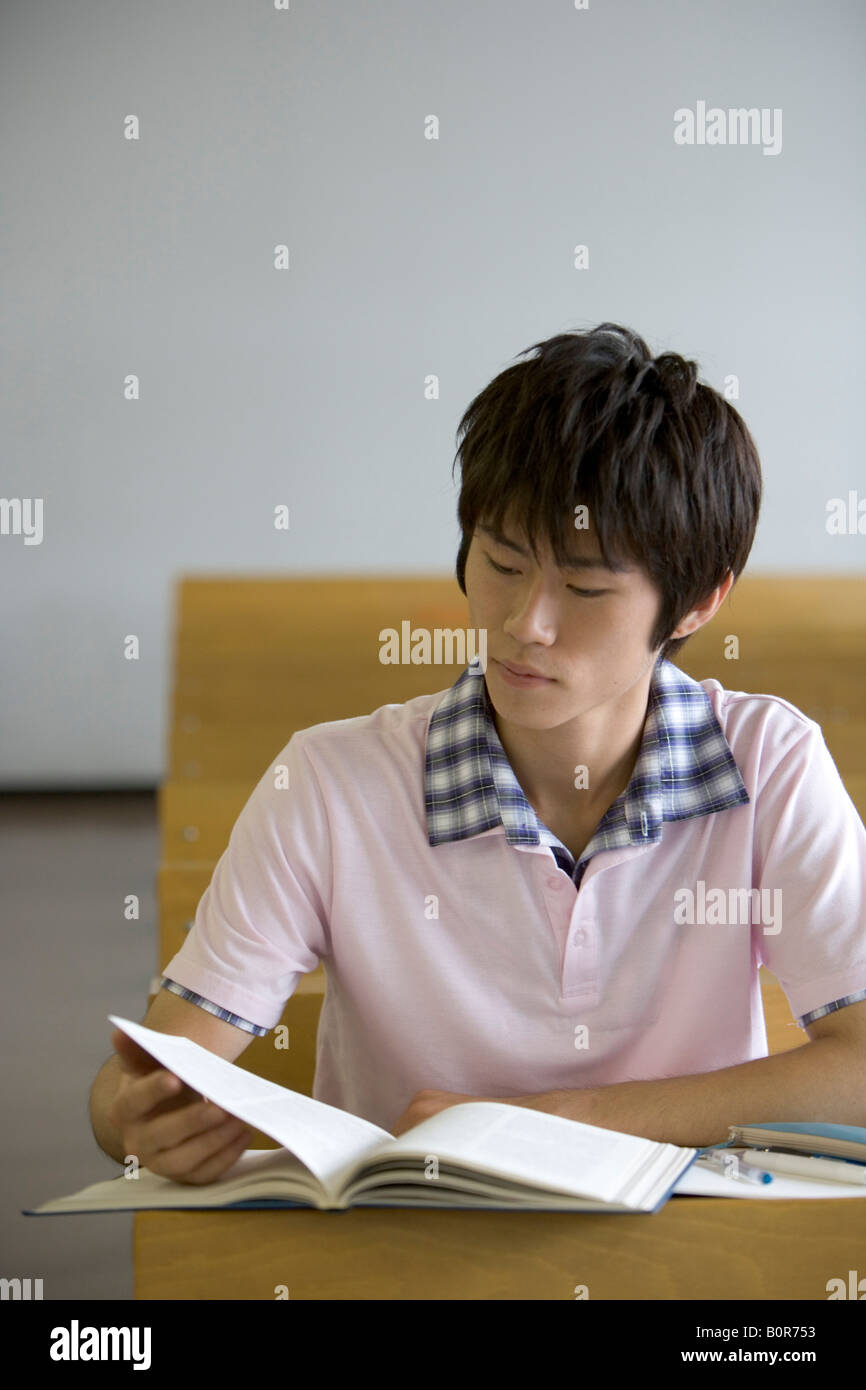 Male student reading in lecture hall Stock Photo - Alamy
