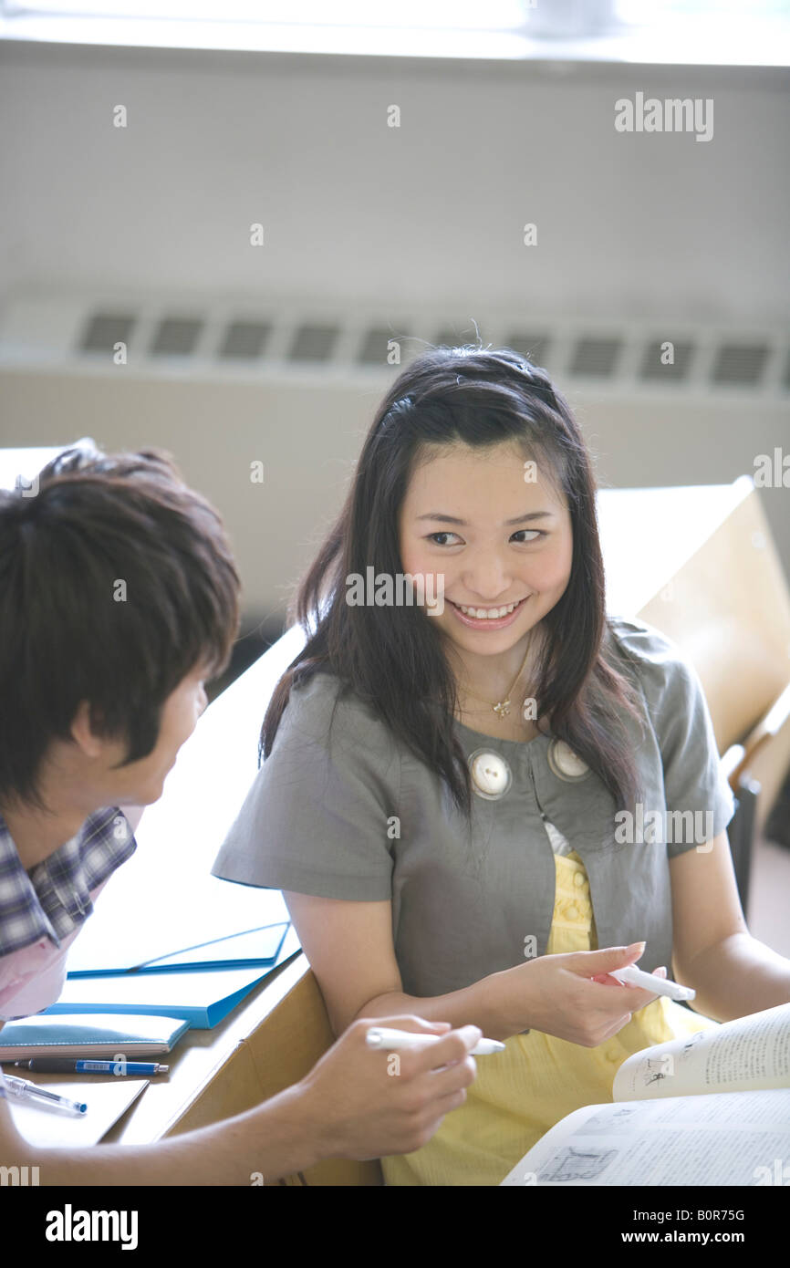 Two students talking in lecture hall Stock Photo - Alamy