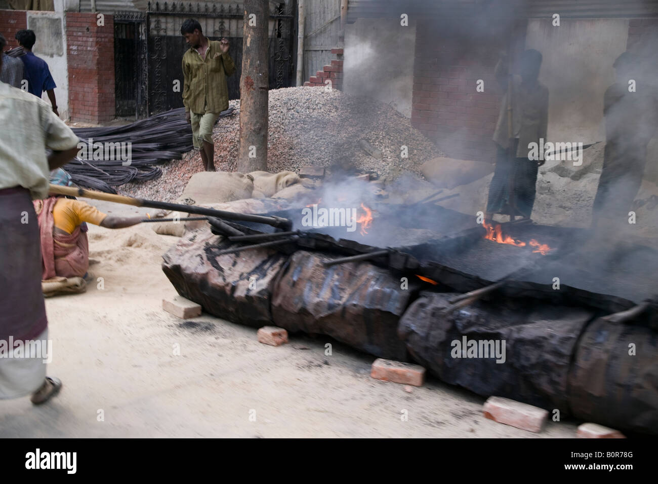 Men burning rocks to make tar in Dhaka Bangladesh Stock Photo - Alamy
