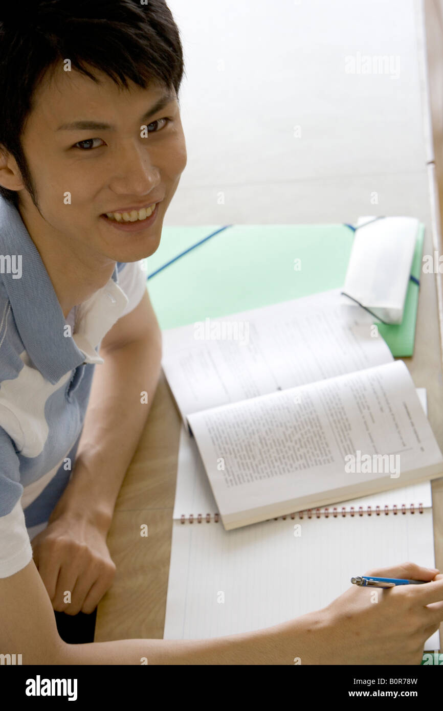 Male student writing at desk Stock Photo - Alamy
