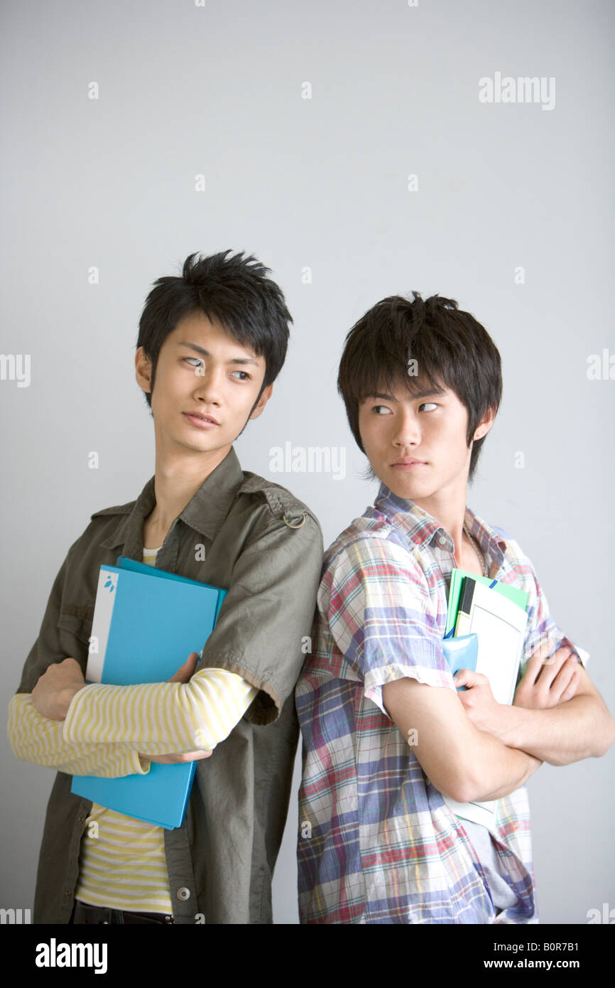 Two male students back to back Stock Photo - Alamy
