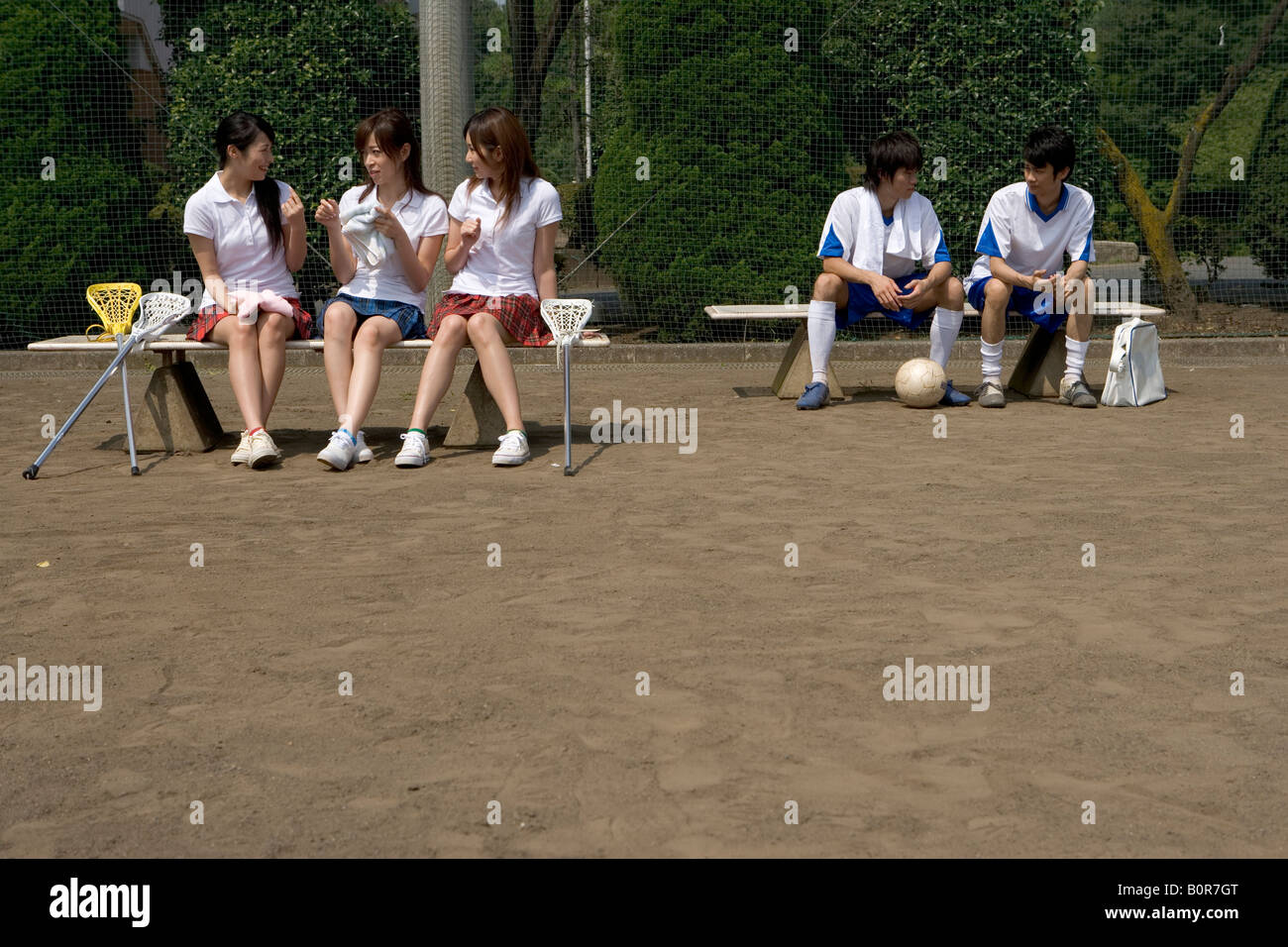 Three girls and two boys sitting on benches during physical education ...