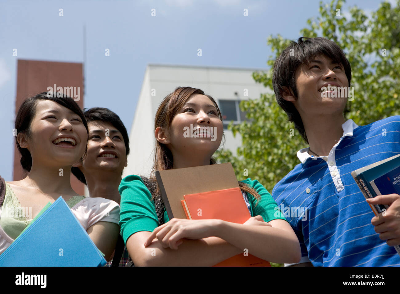Four teenagers standing on street Stock Photo - Alamy