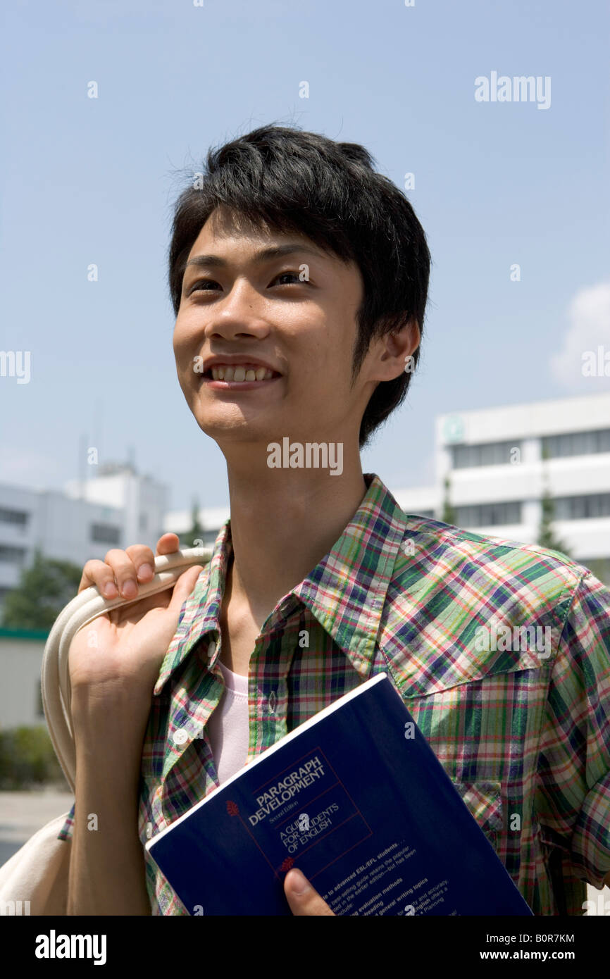 Young male student looking up, outdoors Stock Photo - Alamy