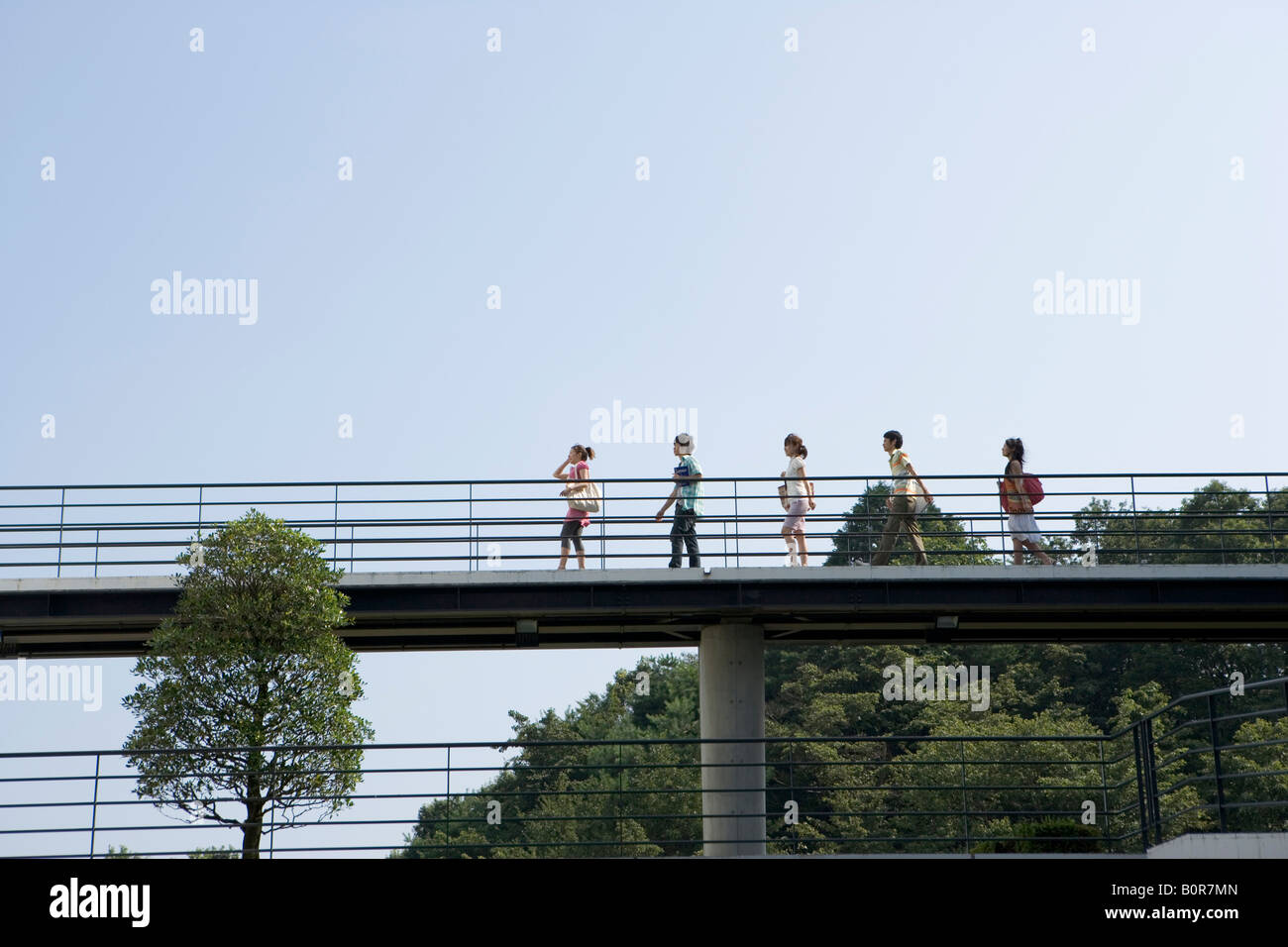 five people walking along walkway Stock Photo - Alamy