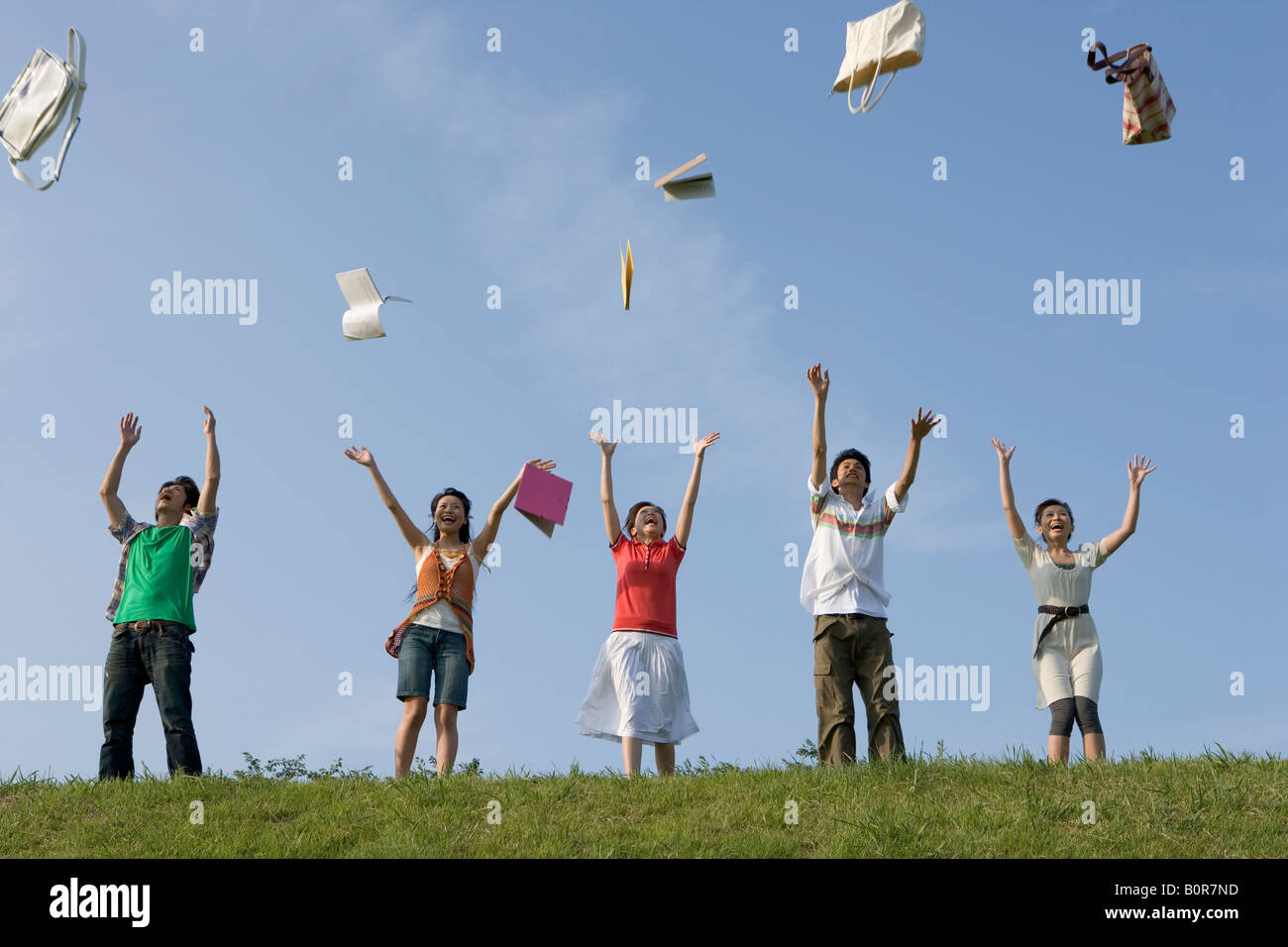 Five young people throwing items in air Stock Photo - Alamy