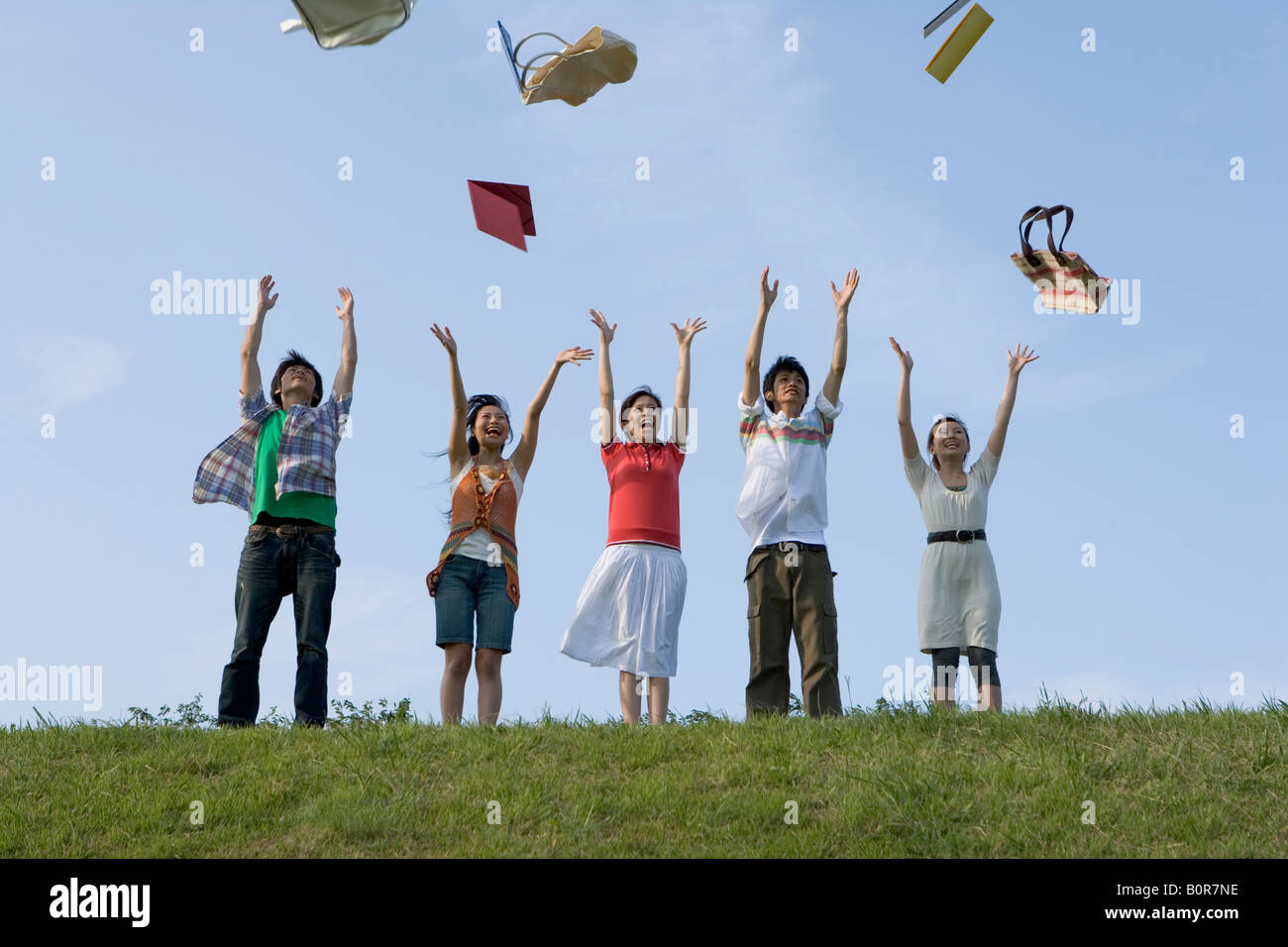Five young people throwing items in air Stock Photo - Alamy
