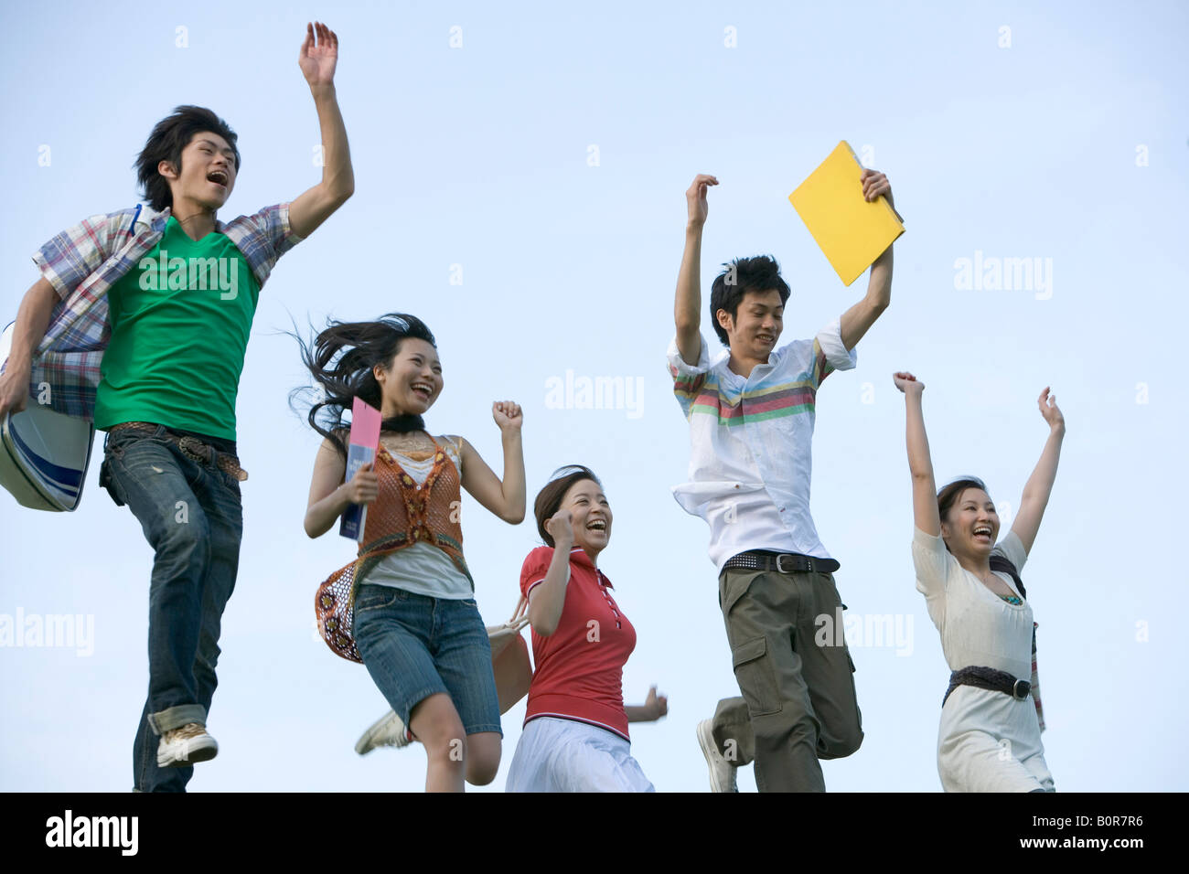 Young people jumping Stock Photo - Alamy