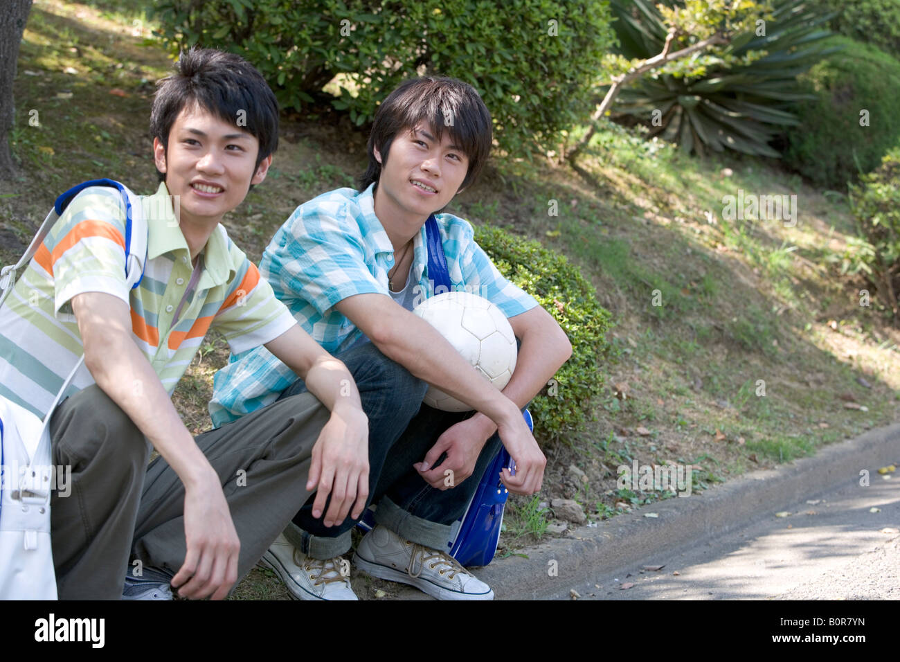Boys sitting roadside hi-res stock photography and images - Alamy