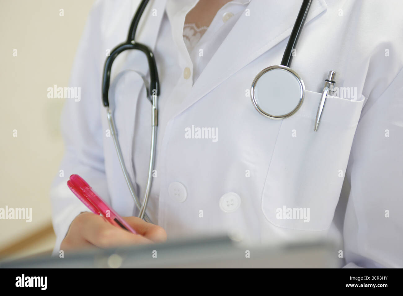 Female doctor holding patient's chart, mid section Stock Photo - Alamy