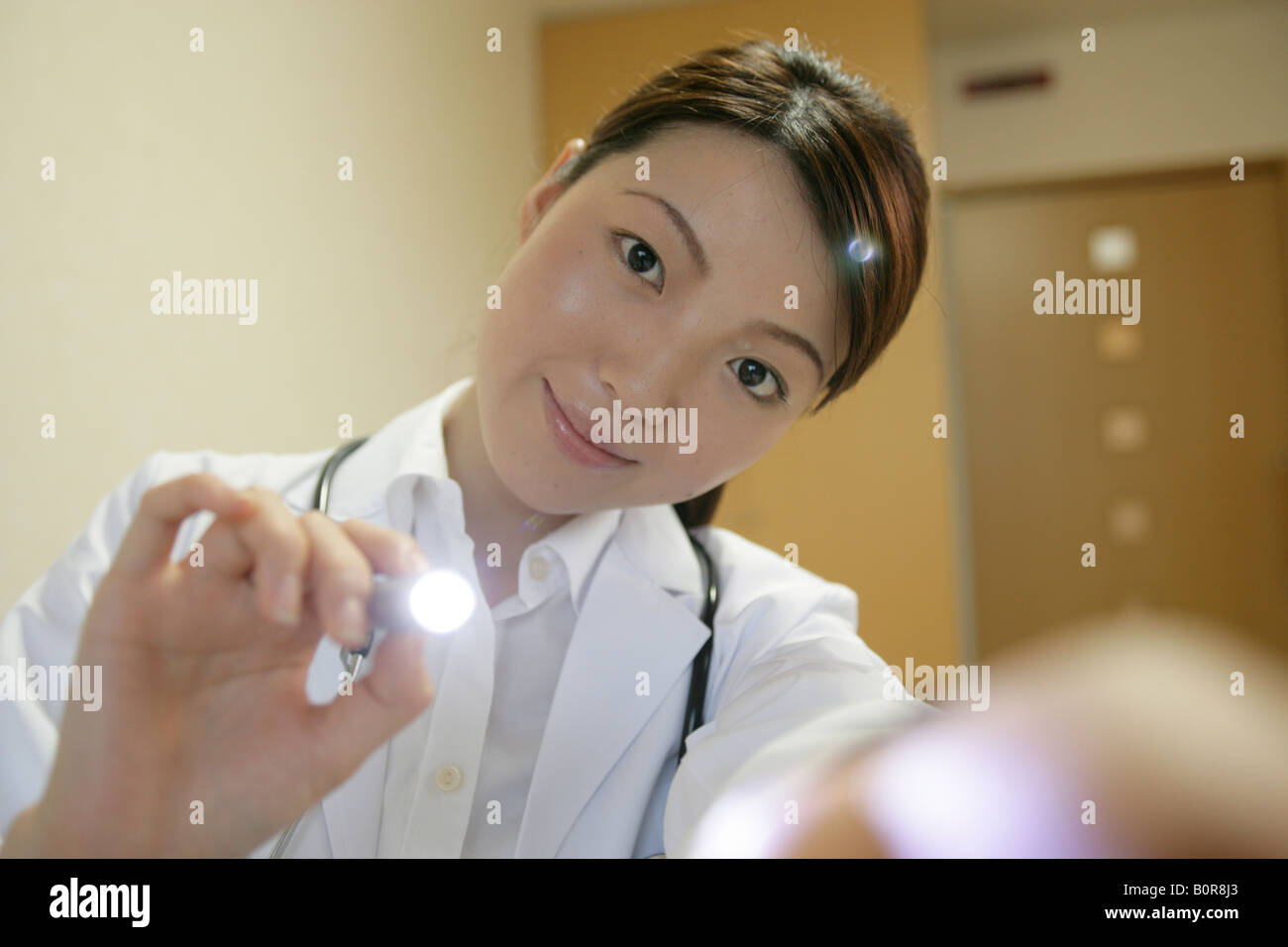 Female doctor holding flashlight, portrait Stock Photo - Alamy