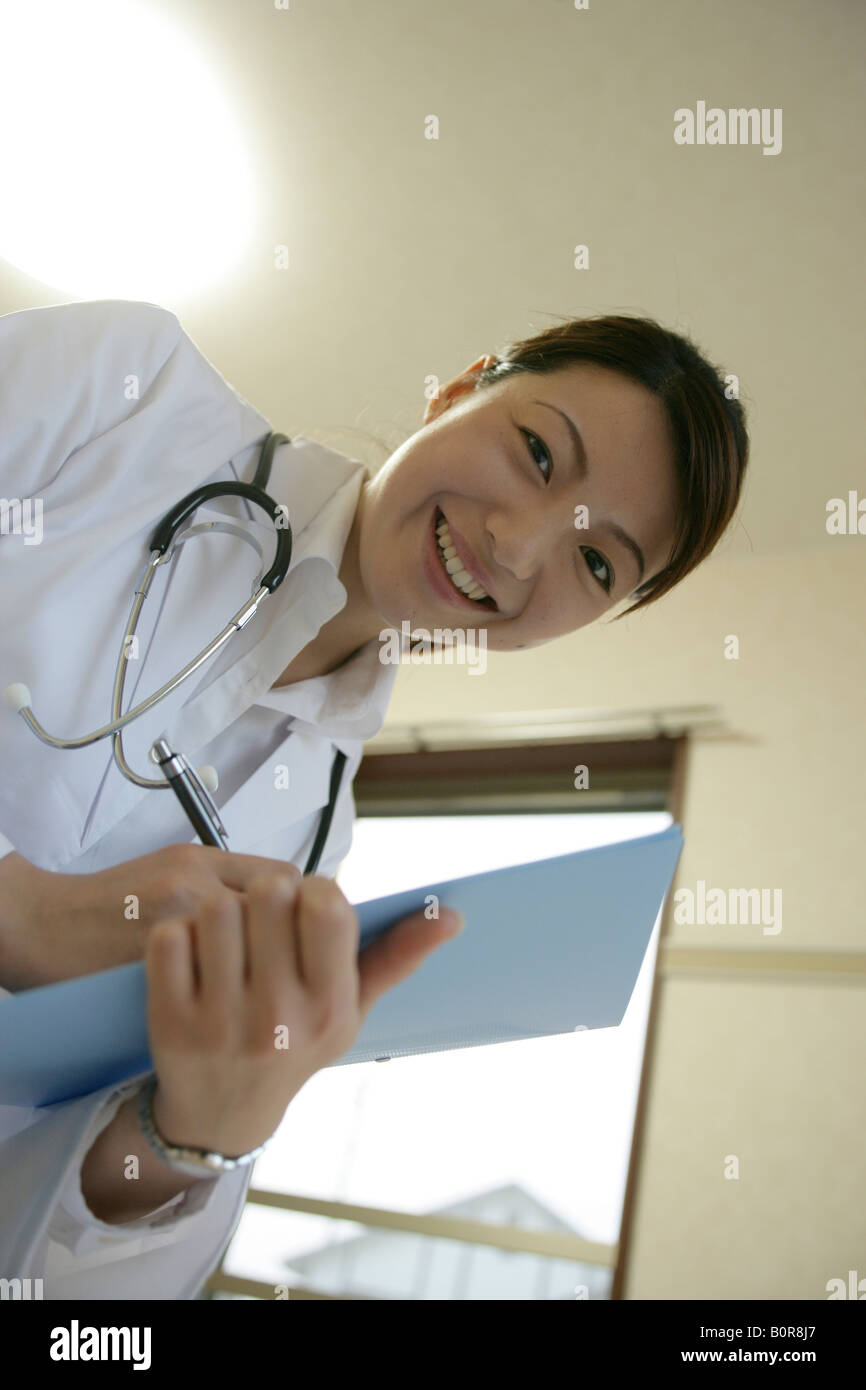 Female doctor holding patient's chart, portrait Stock Photo - Alamy