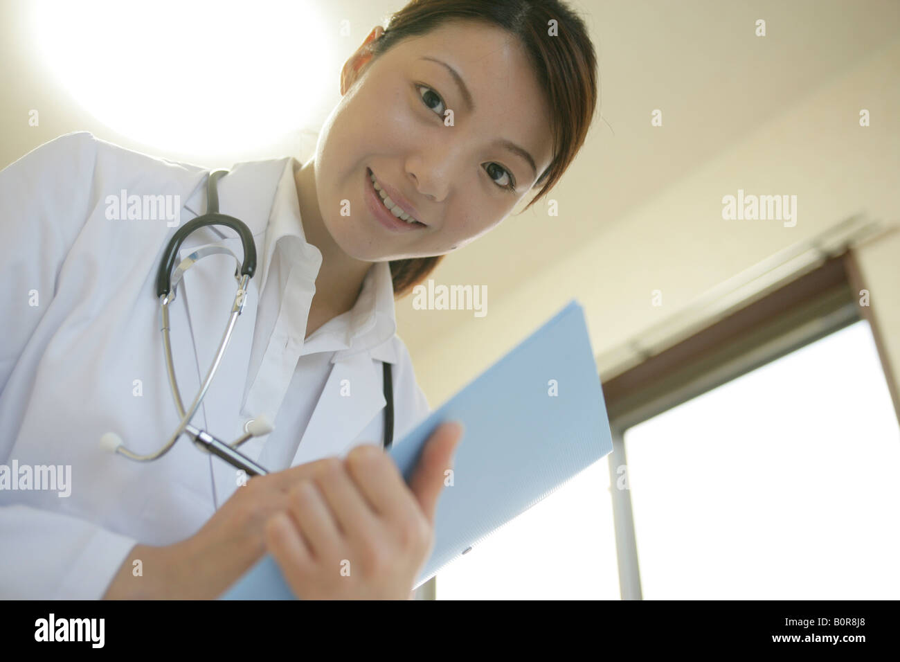 Female doctor holding patient's chart, portrait Stock Photo - Alamy