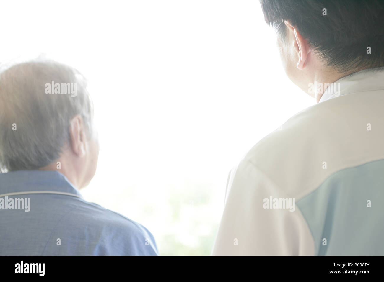 Male nurse and senior man facing window, rear view Stock Photo - Alamy