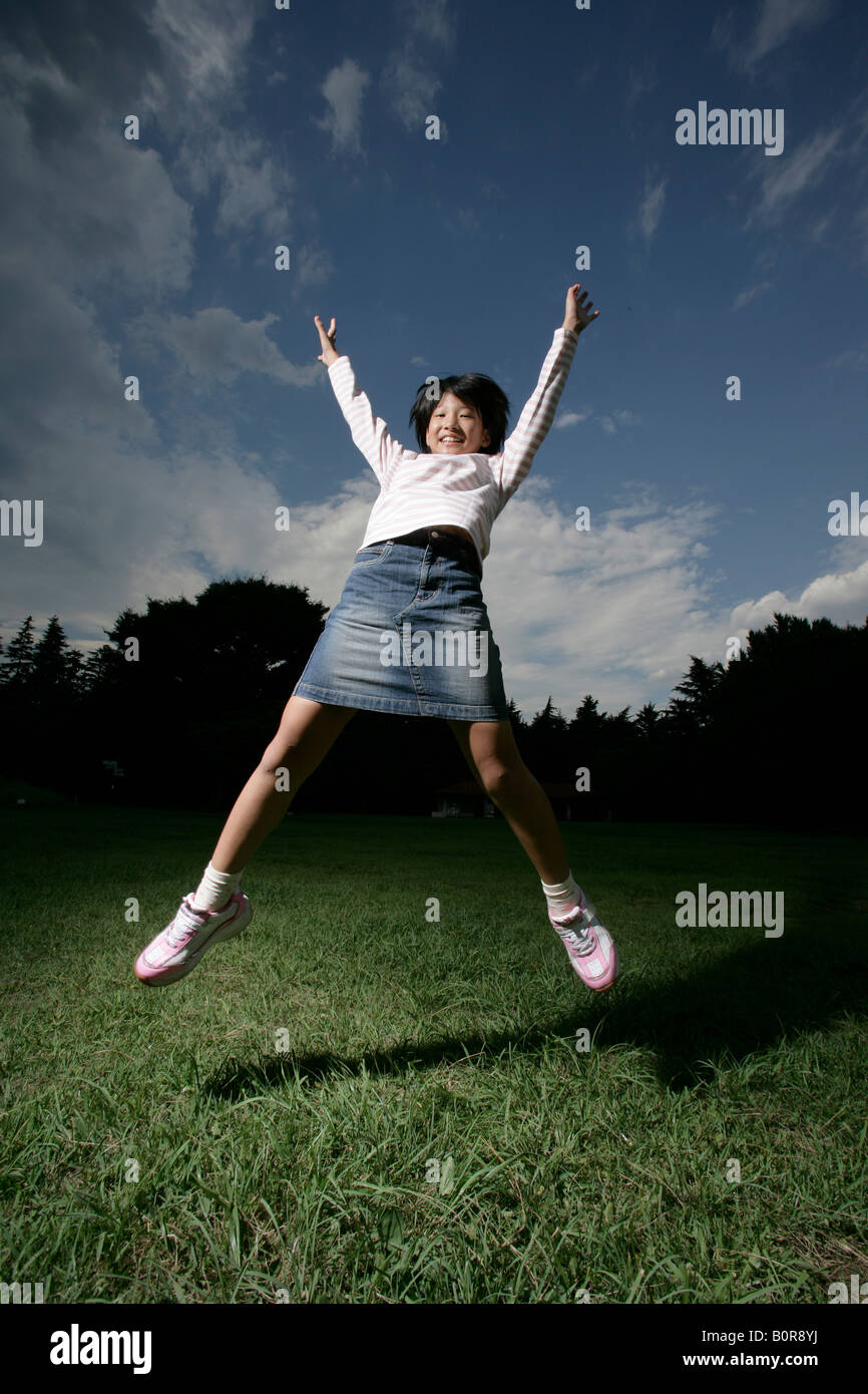 Teenage girl (14-15) jumping on grass Stock Photo - Alamy