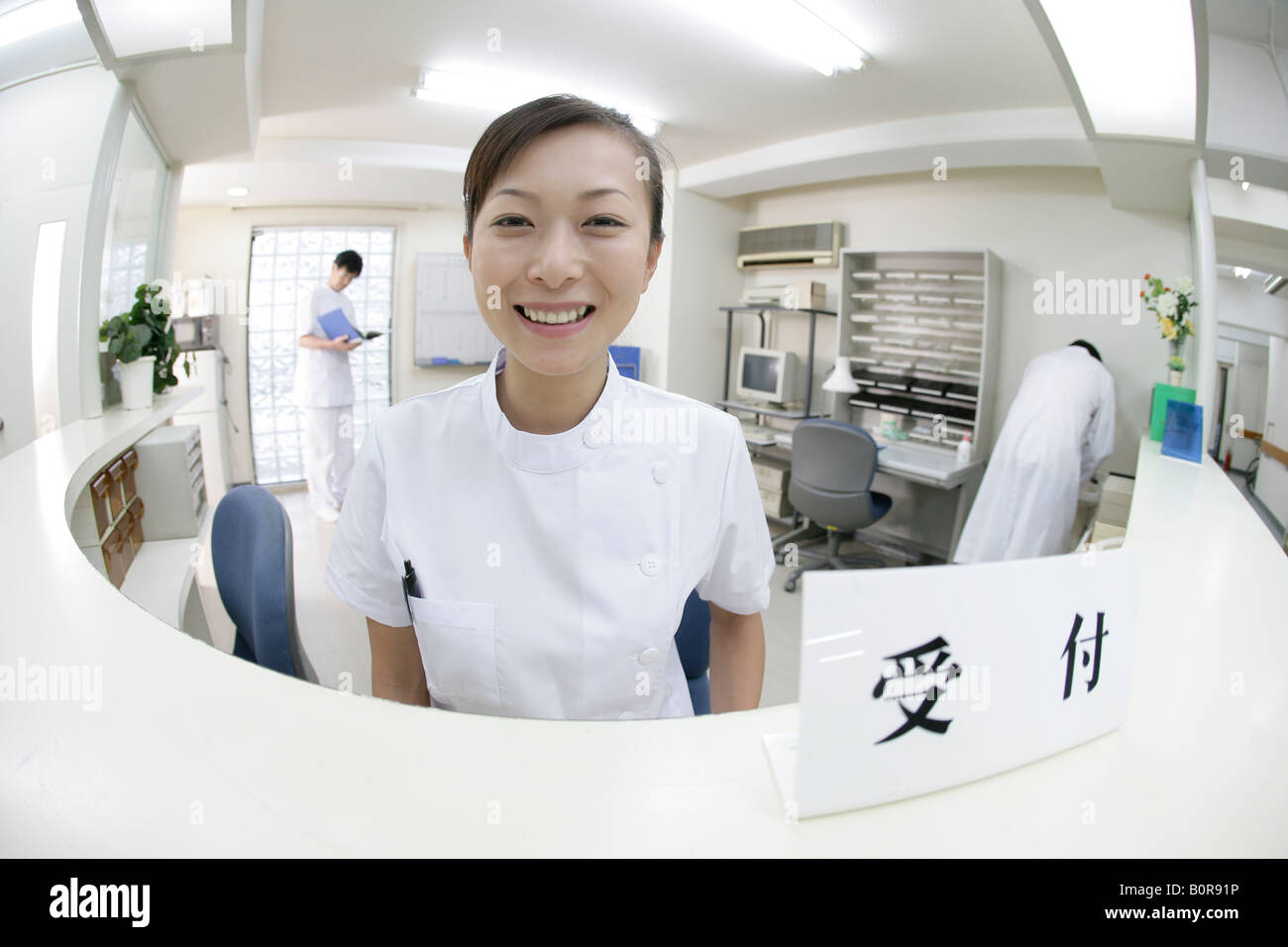 Portrait of female nurse at hospital counter, fish eye lens Stock Photo ...