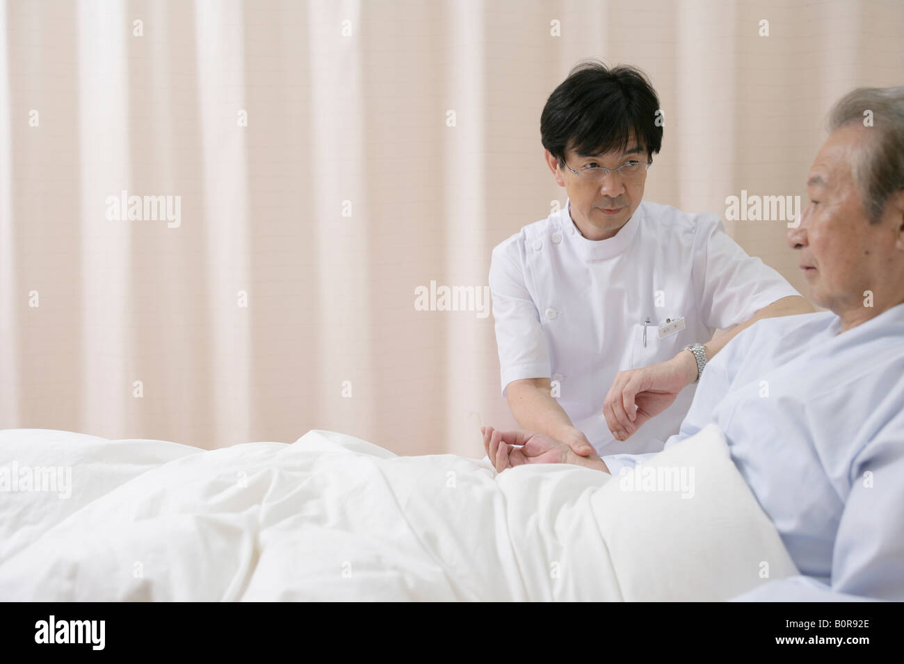 Male nurse checking patient's pulse Stock Photo - Alamy