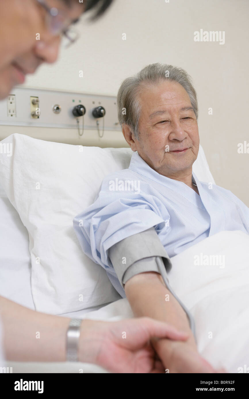 Male nurse checking patient's pulse Stock Photo - Alamy
