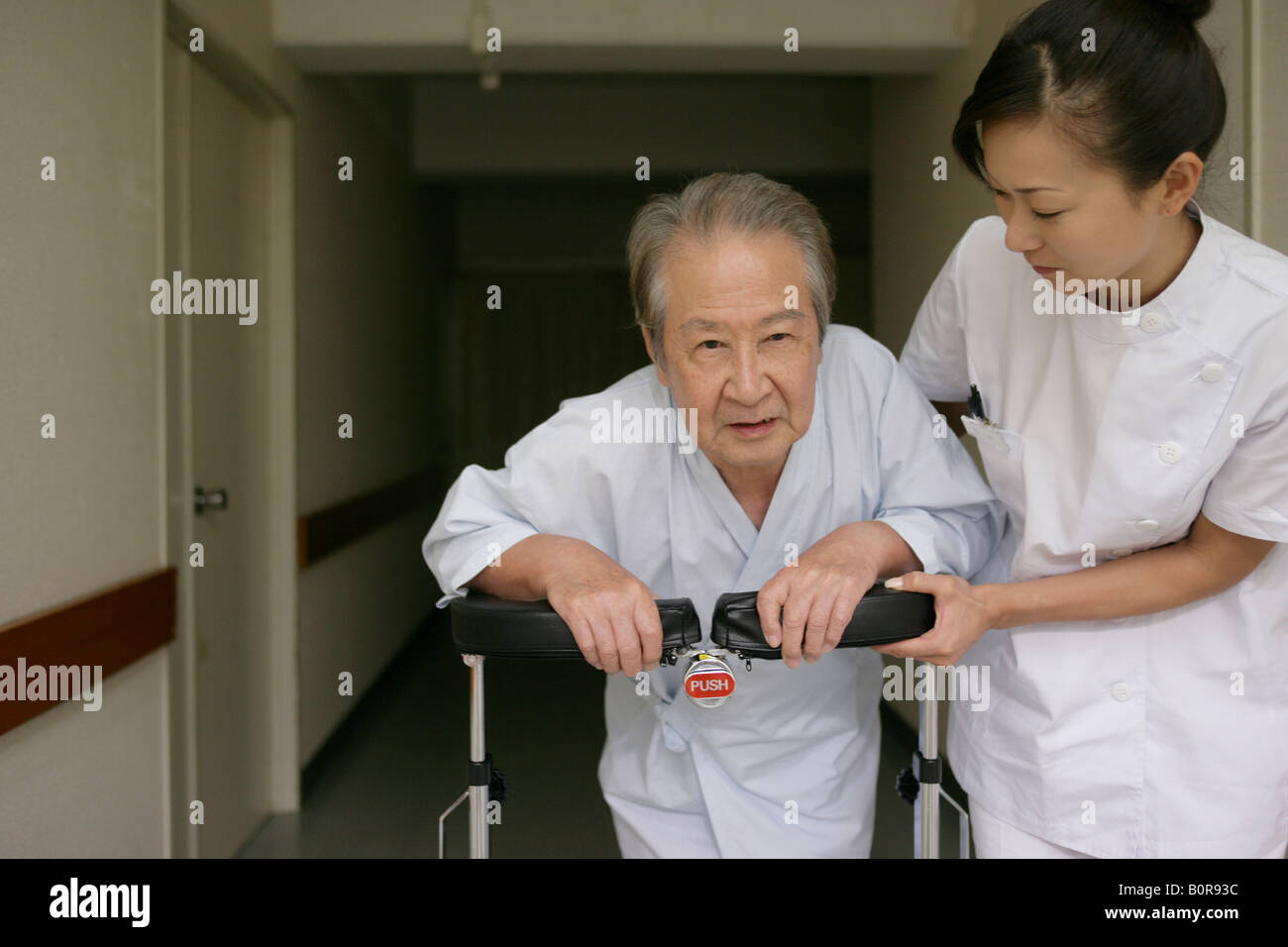 Female nurse assisting senior man walking with walker Stock Photo - Alamy
