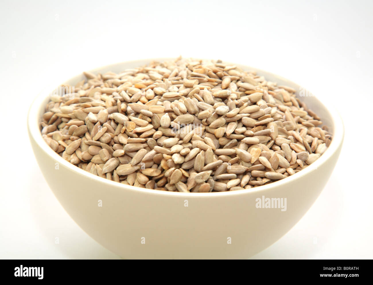 Sunflower seeds in a cream bowl against a white background Stock Photo ...