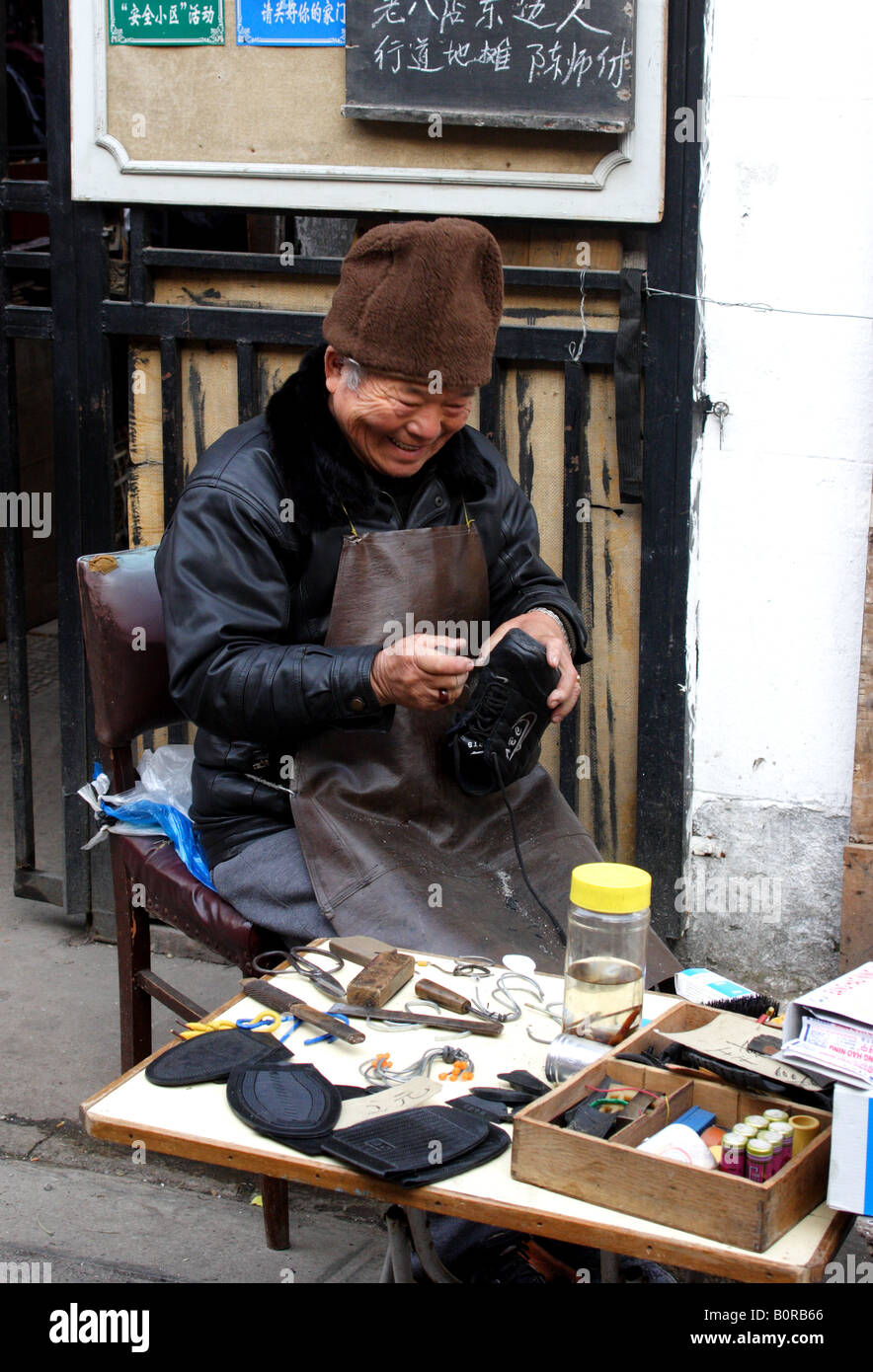 A cobbler works on the street in Shanghai Stock Photo - Alamy