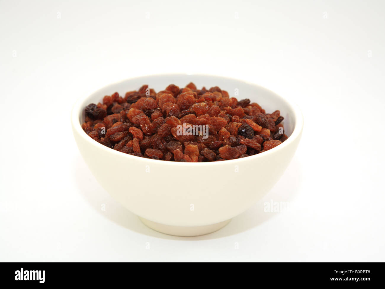 Sultanas in a bowl on a white background Stock Photo - Alamy