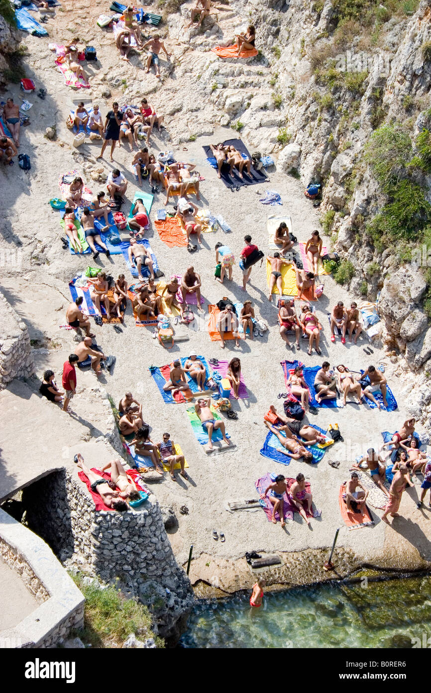 PEOPLE SUNBATHING AND ENJOYING THE SUN ON THEIR COLOURED SEA TOWELS ...