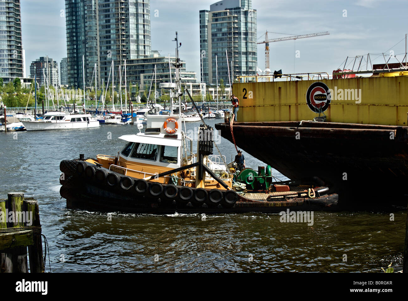 Tugboat crewman attaching hawsers tow ropes to a barge in Vancouver s ...