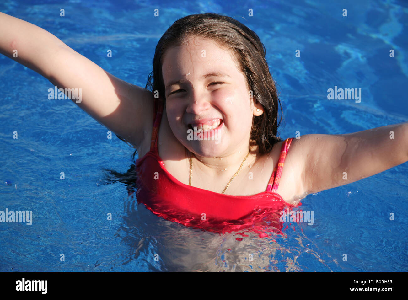 Happy girl playing in a pool on a sunny day Stock Photo - Alamy