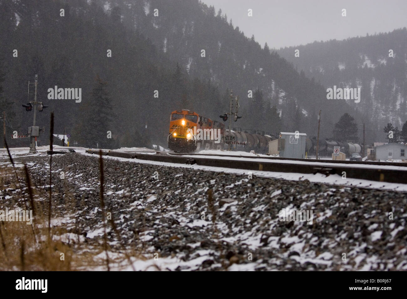 BNSF freight train steams through the Rocky Mountains during a cold ...