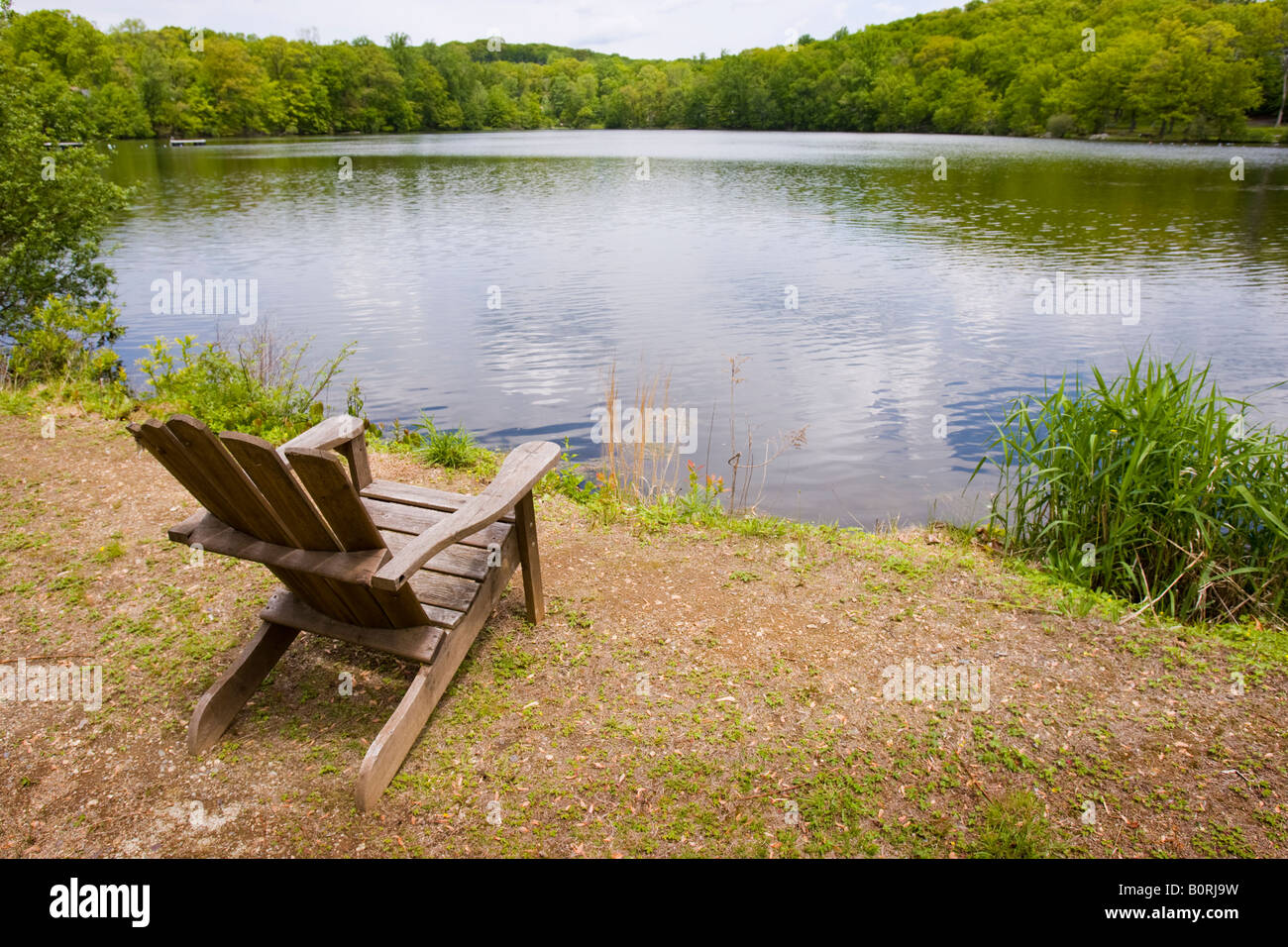 Chair by the side of a lake Stock Photo - Alamy