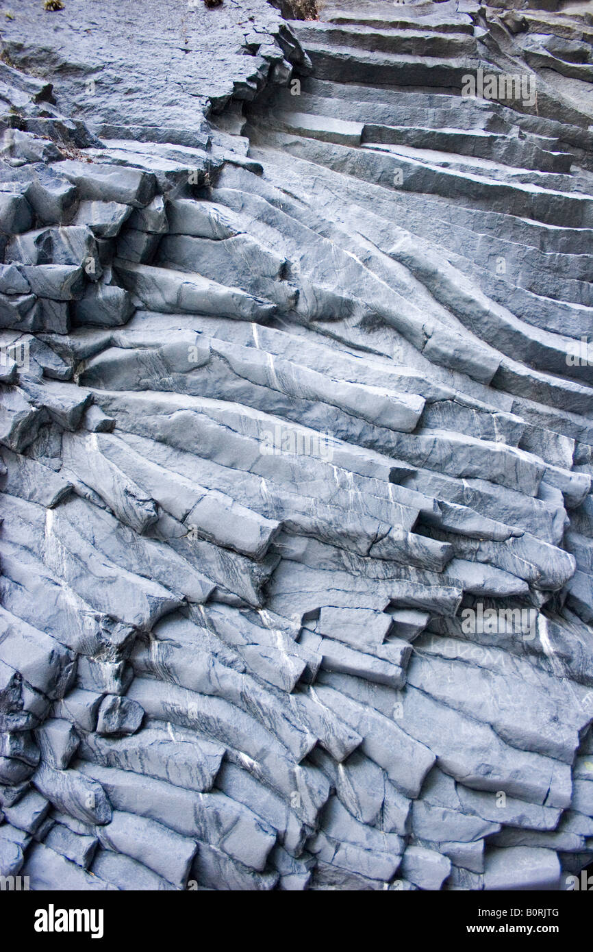 grey coloured volcanic rocks made from lava in a lines formation at the ...