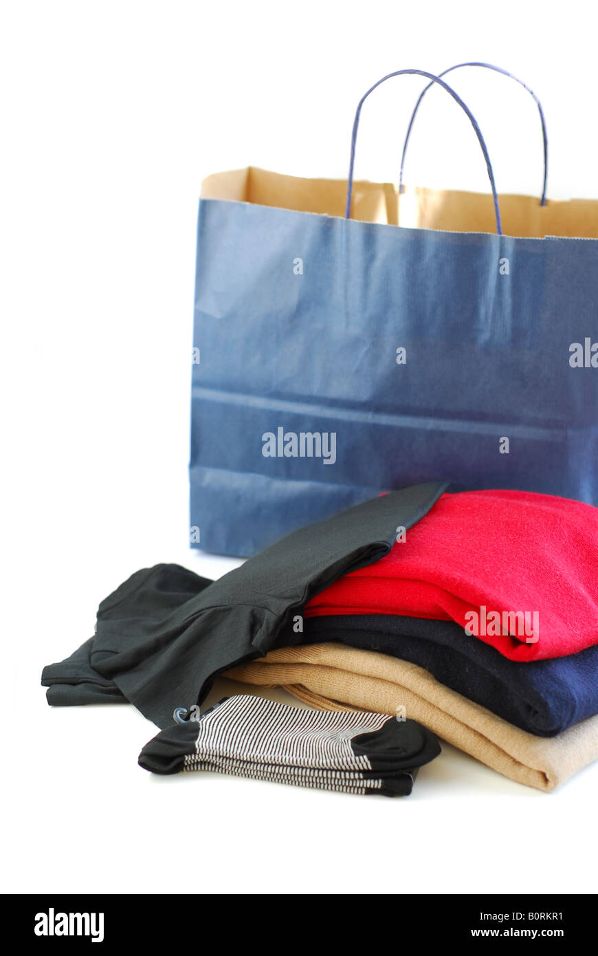 Folded sweaters with a paper shopping bag on white background Stock ...
