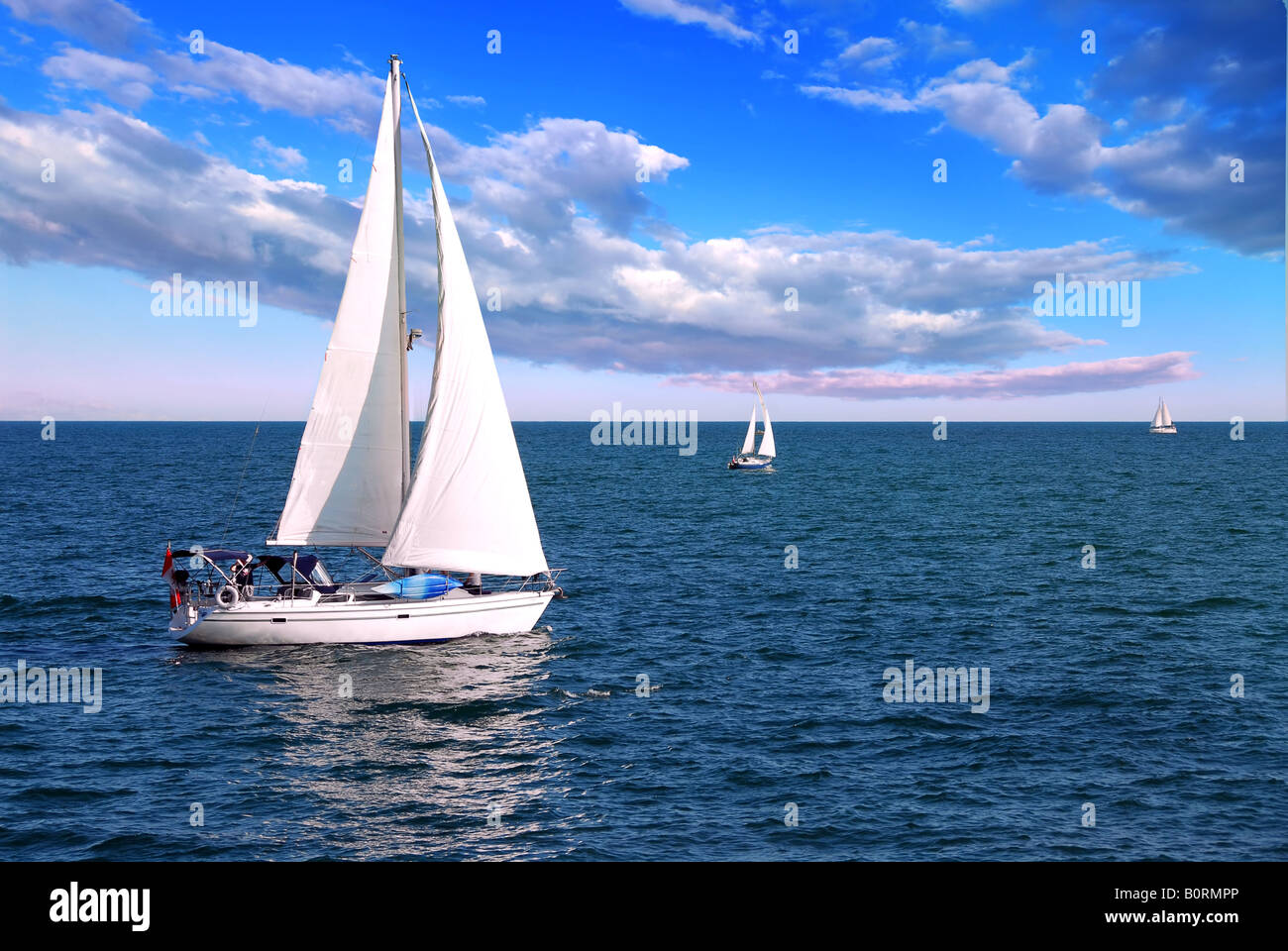 Sailboat sailing in the morning with blue cloudy sky Stock Photo - Alamy