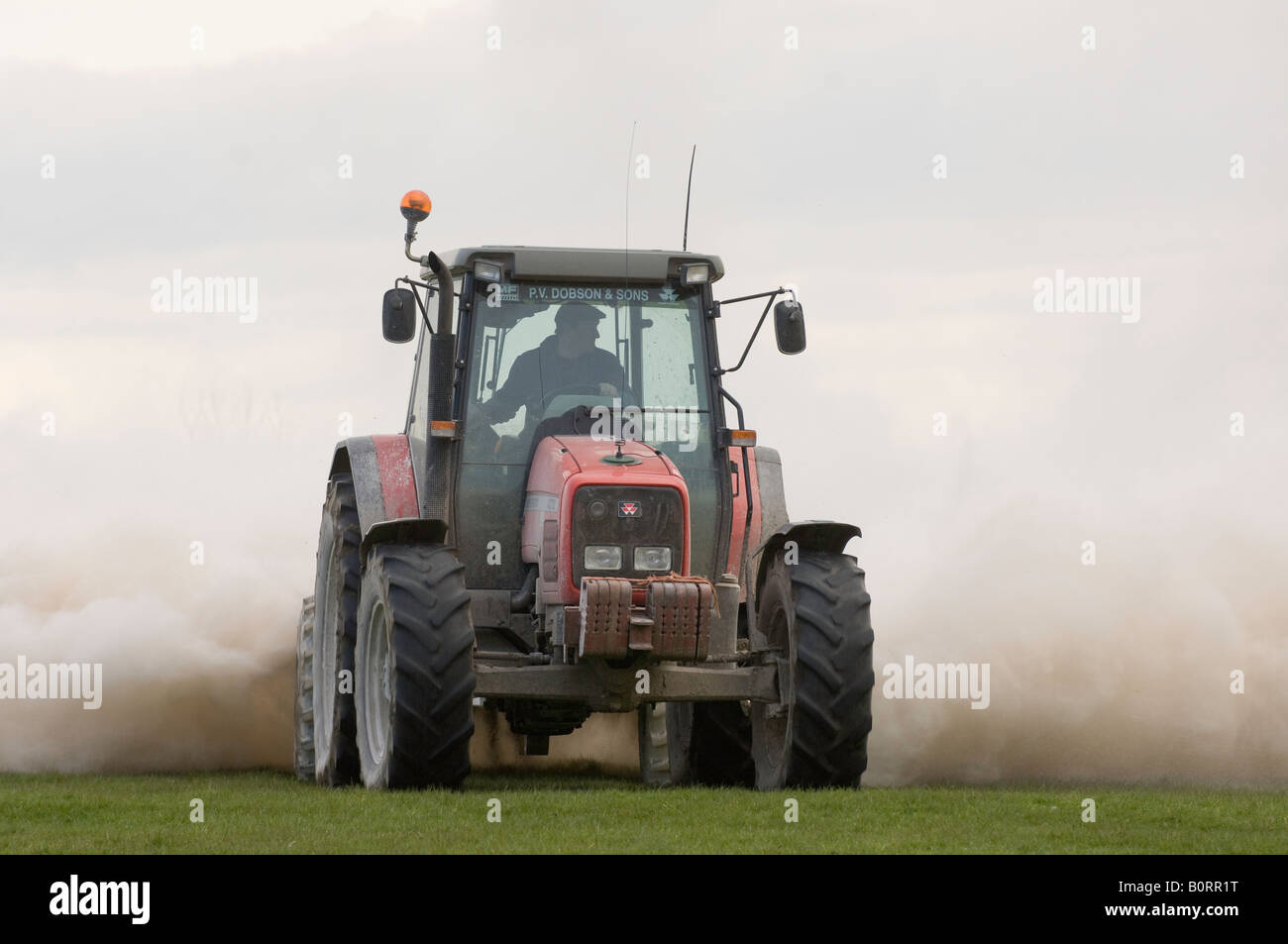 Massey Ferguson tractor pulling a lime spreader which is spreading ...