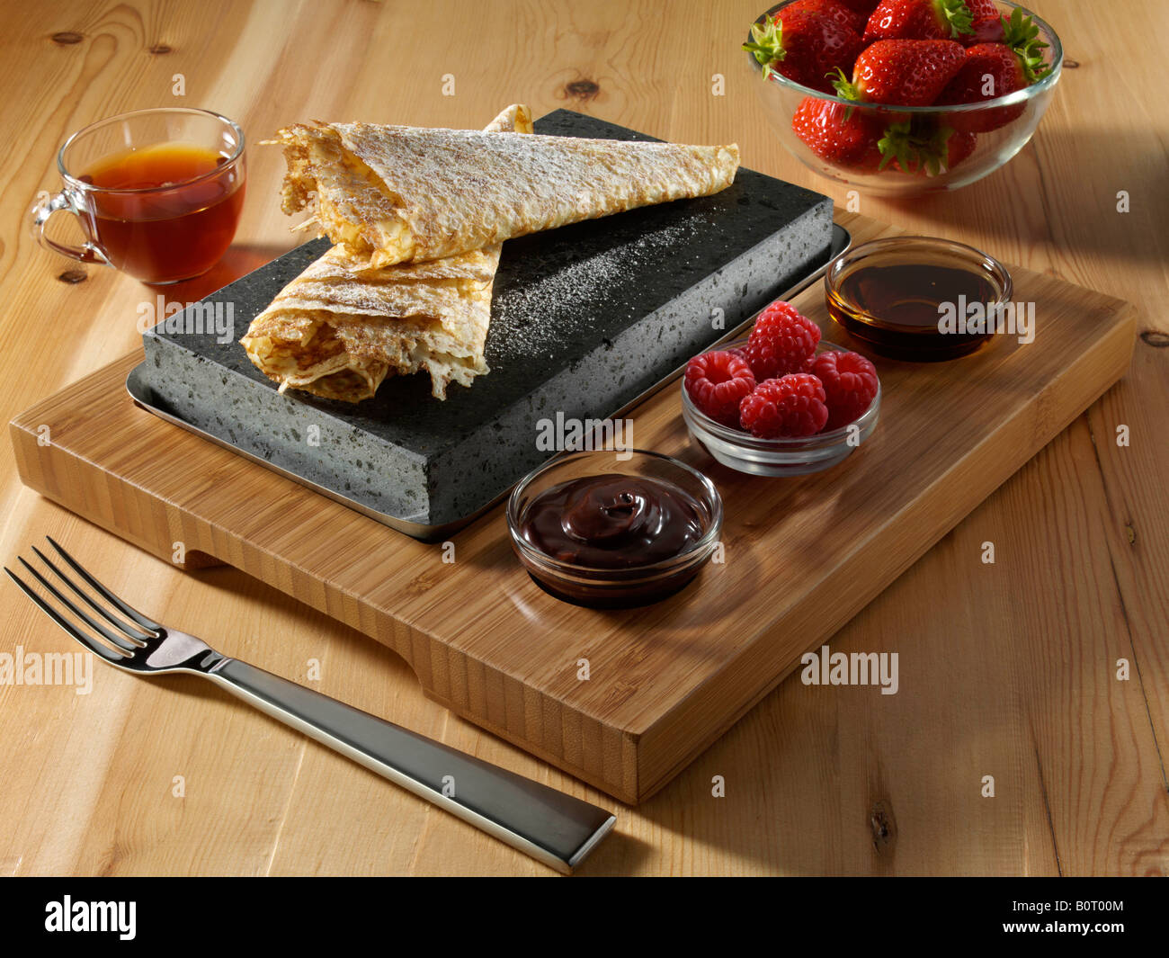 Pancakes cooking on a hot lava stone editorial food Stock Photo - Alamy