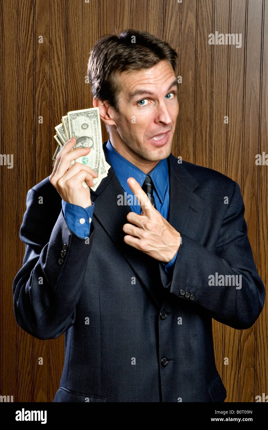 Businessman holding money up to his face laughing Stock Photo - Alamy