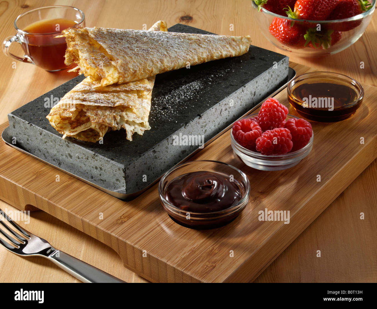 Pancakes cooking on a hot lava stone editorial food Stock Photo - Alamy