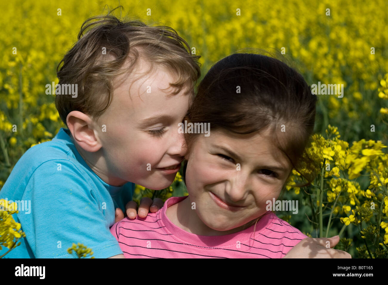 young boy and girl frolicking in a summer field Stock Photo - Alamy