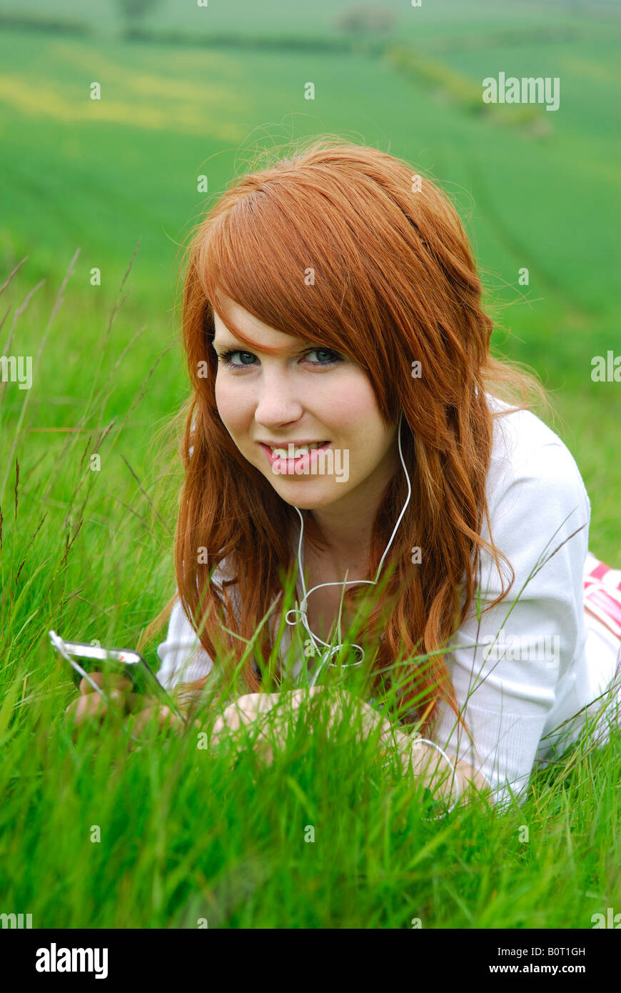 Young women listening to mp3 player Stock Photo - Alamy