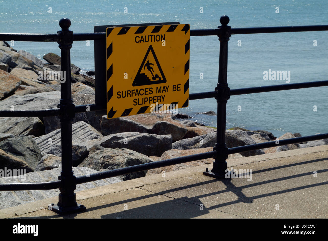 Warning sign of Slippery surface on rocks at the seaside Stock Photo ...