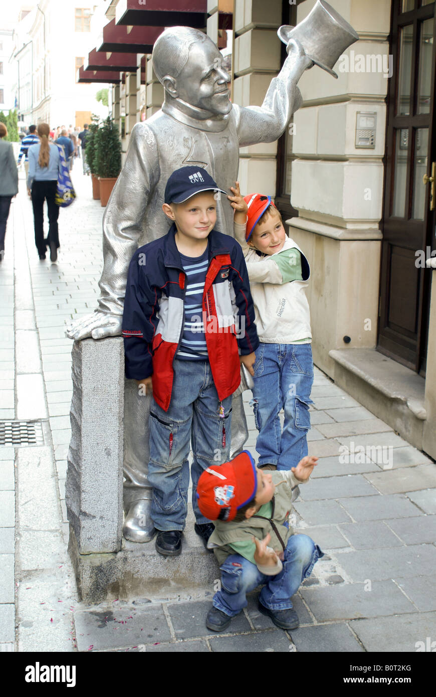 Kids posing for a photo with one of the statues in the streets of ...