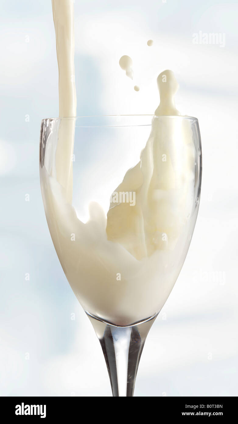 Milk being poured into a glass against a white background Stock Photo ...