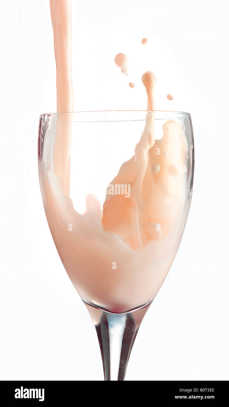 Milk Shake being poured into a glass against a white background Stock ...