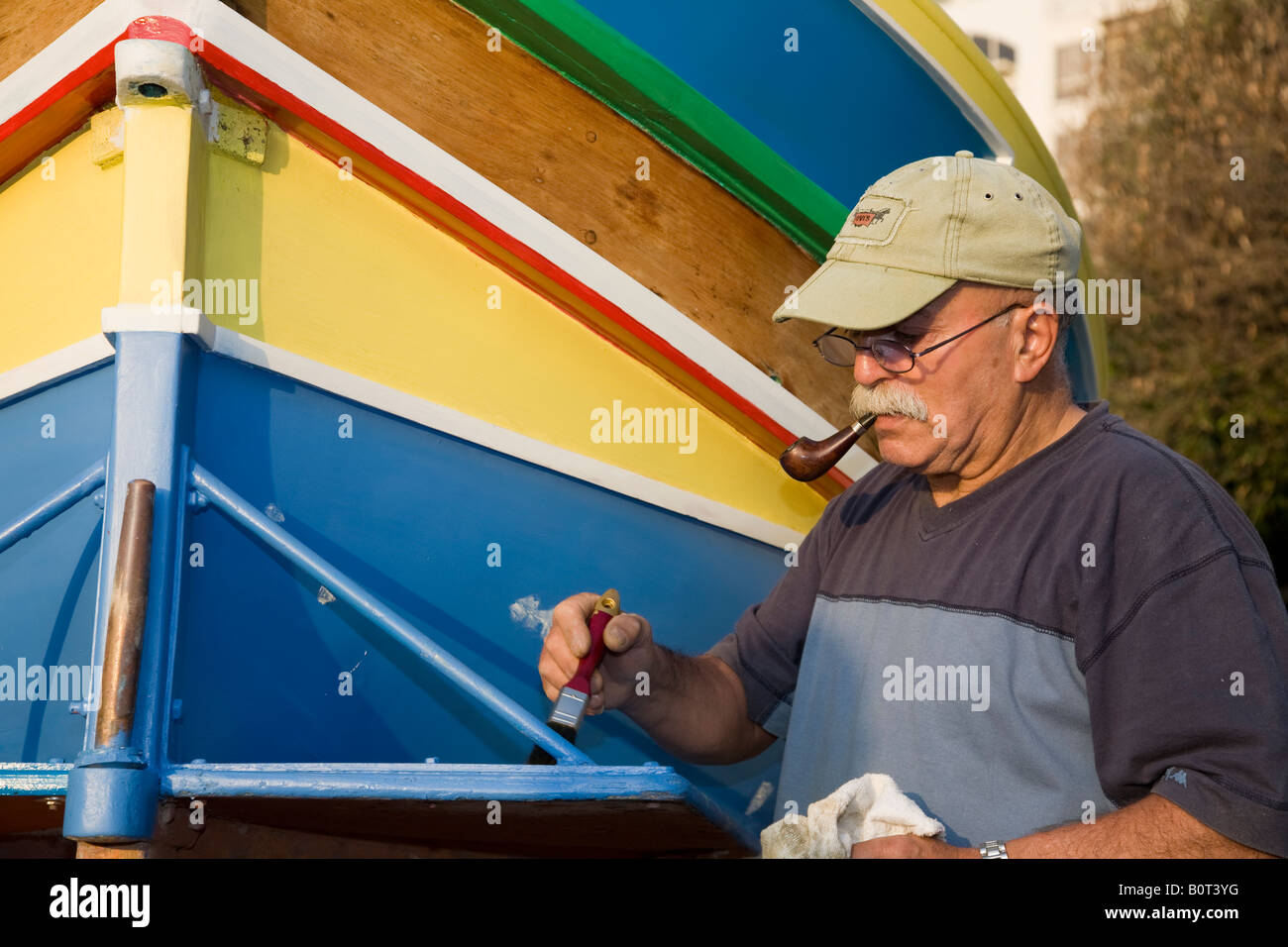 Traditional Maltese fishing boat; Fisherman repainting a Luzzu Eye of ...